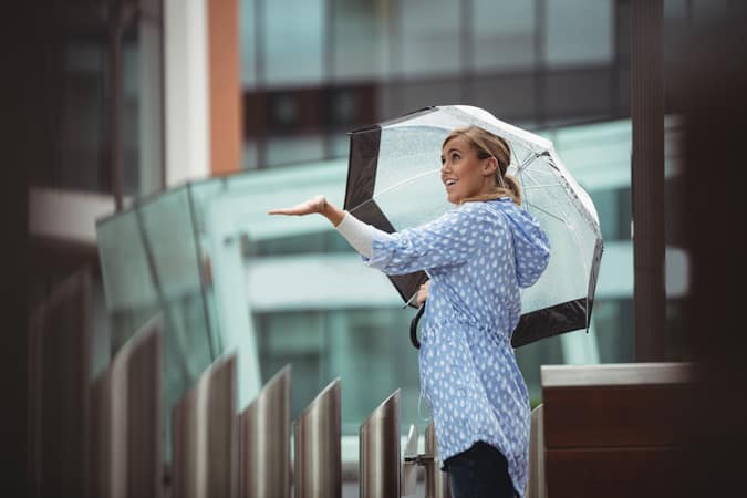 Beautiful woman enjoying rain during rainy season - South Florida Reporter